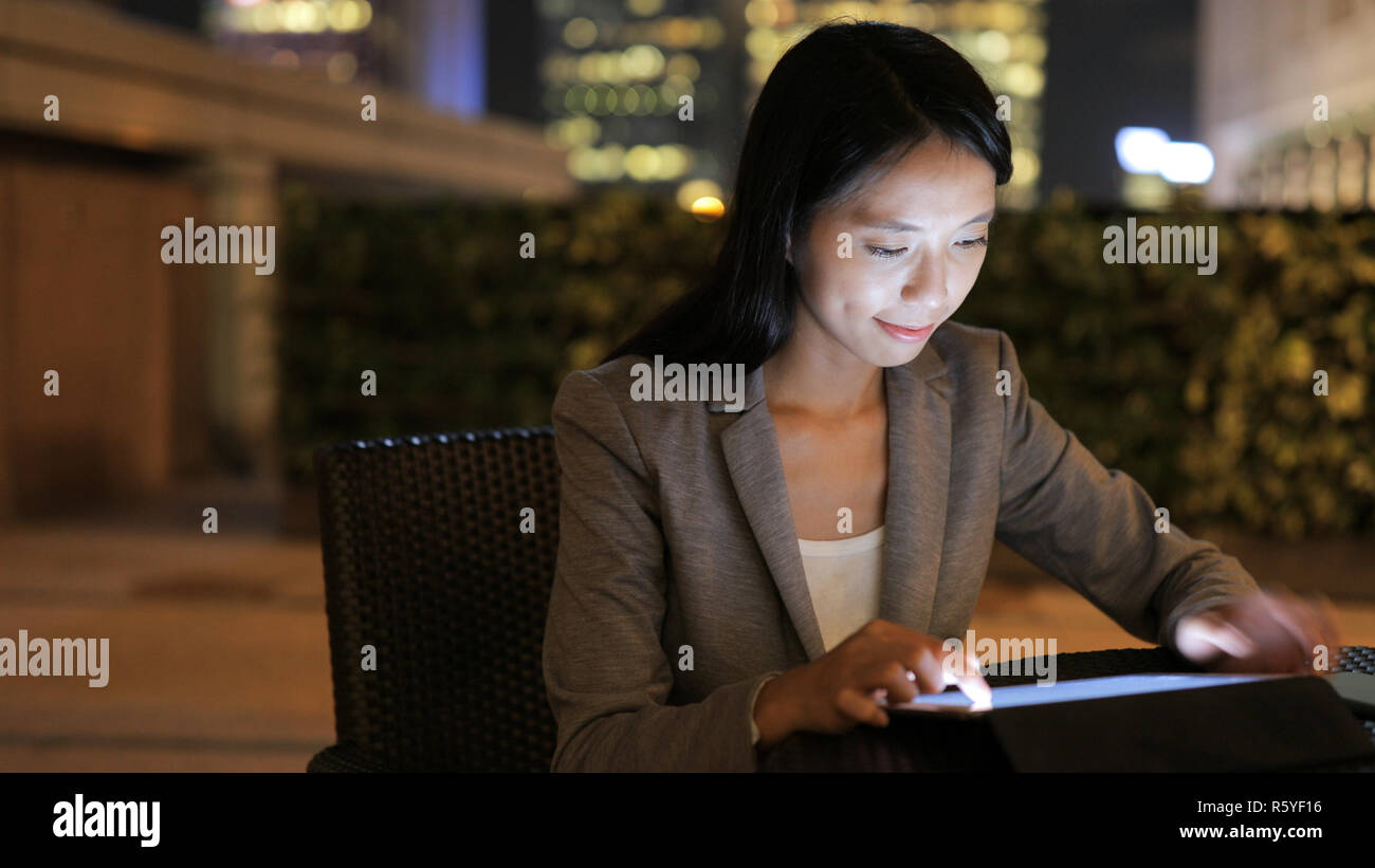 Asian Business woman use of tablet computer at night Stock Photo - Alamy