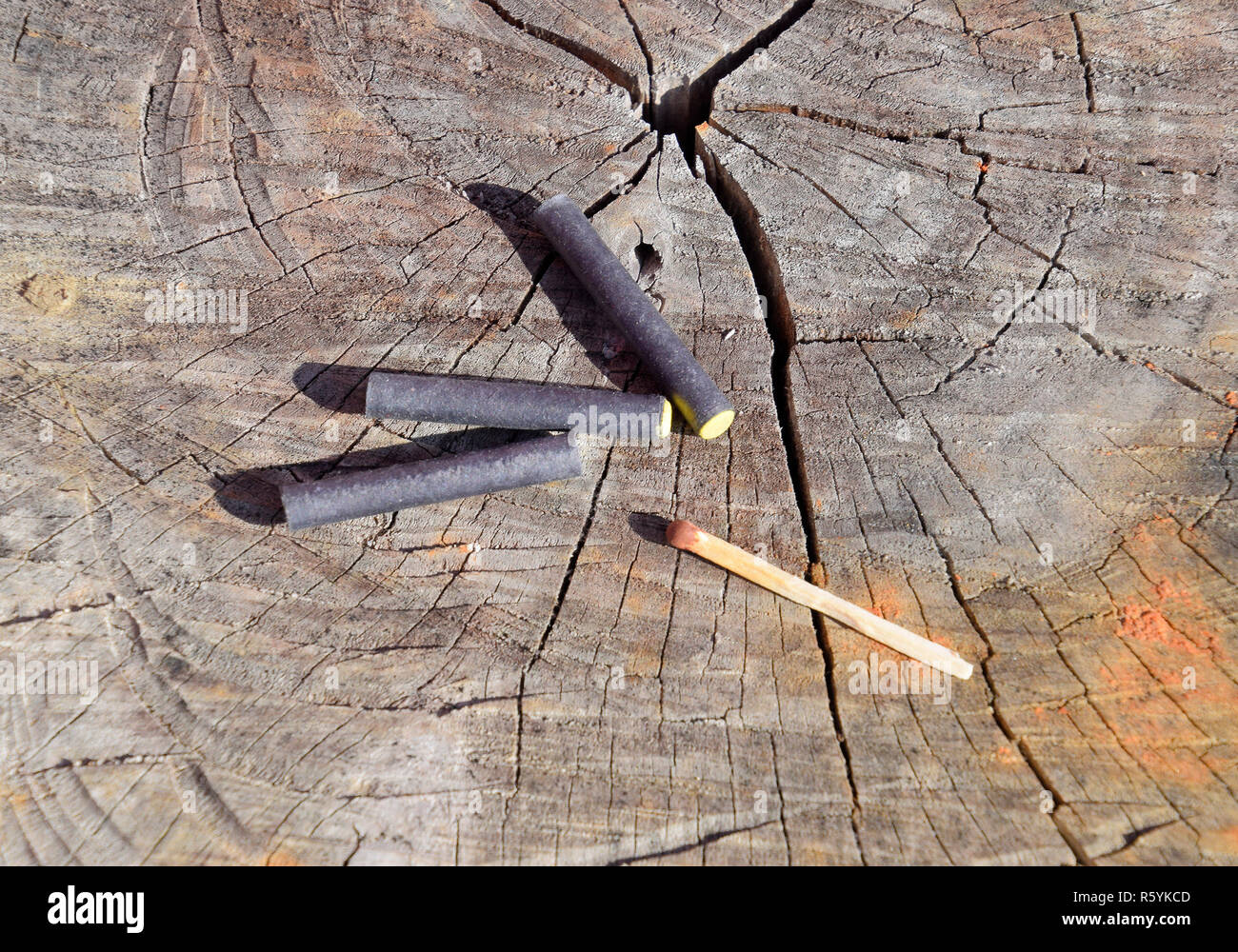 Three firecrackers and match lying on a tree stump Stock Photo - Alamy