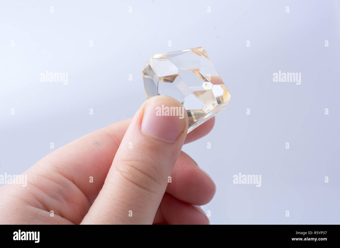 Hand holding a transparent diamond on a white background Stock Photo ...