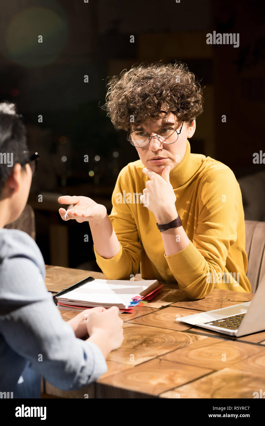 Confused lady asking questions to colleague Stock Photo - Alamy