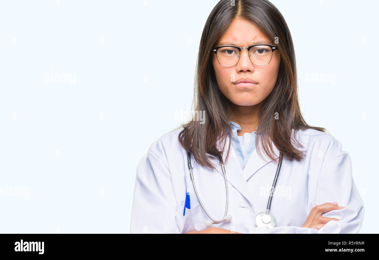 Young asian doctor woman over isolated background skeptic and nervous ...