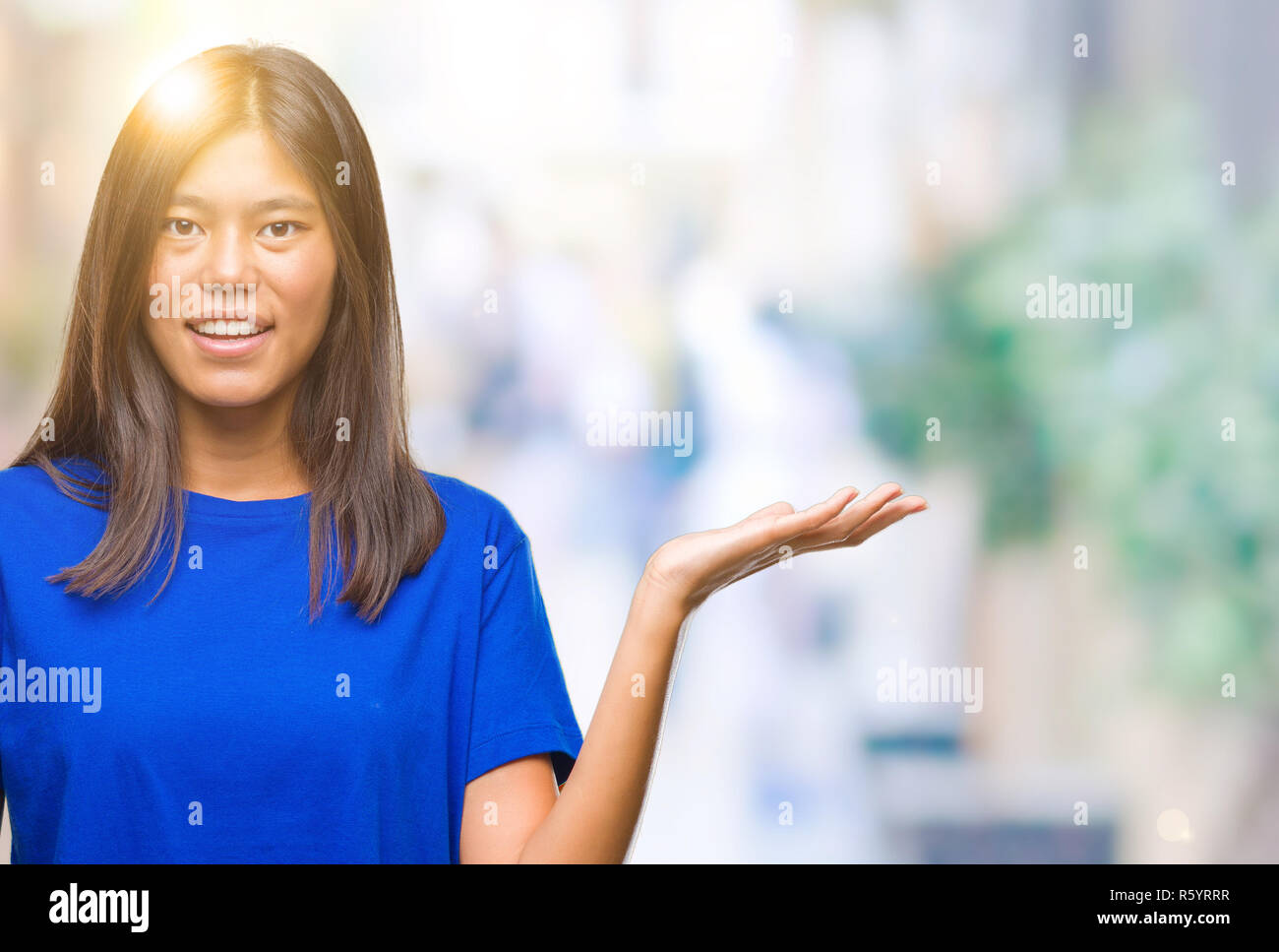 Young asian woman over isolated background smiling cheerful presenting ...