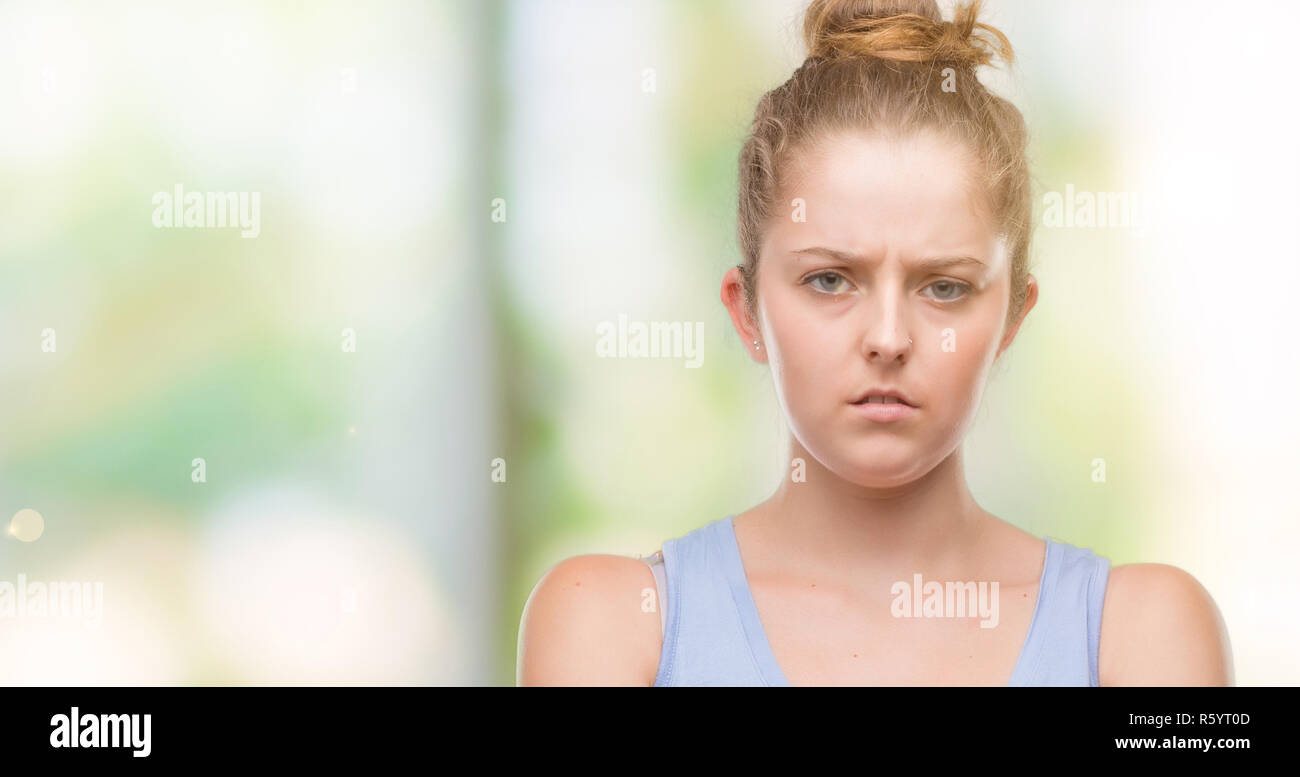 Young blonde woman skeptic and nervous, disapproving expression on face ...