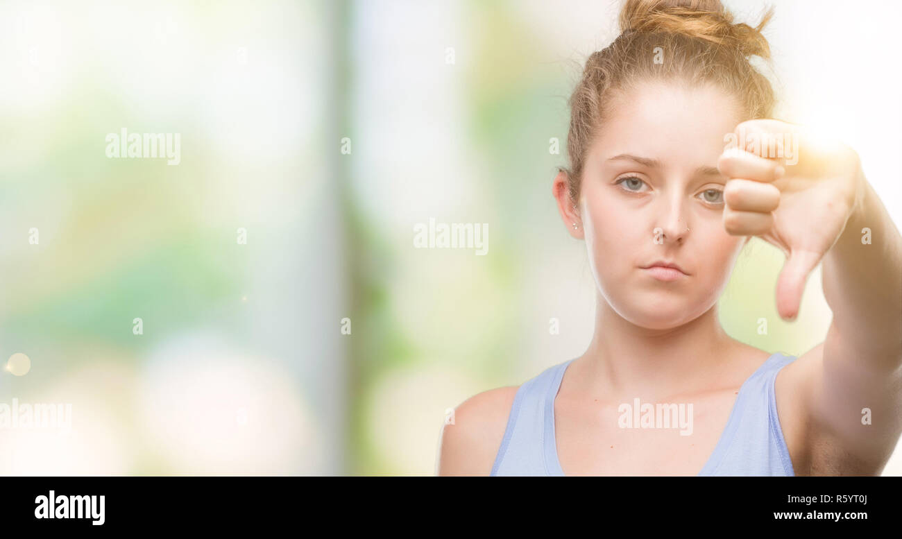 Young blonde woman looking unhappy and angry showing rejection and ...