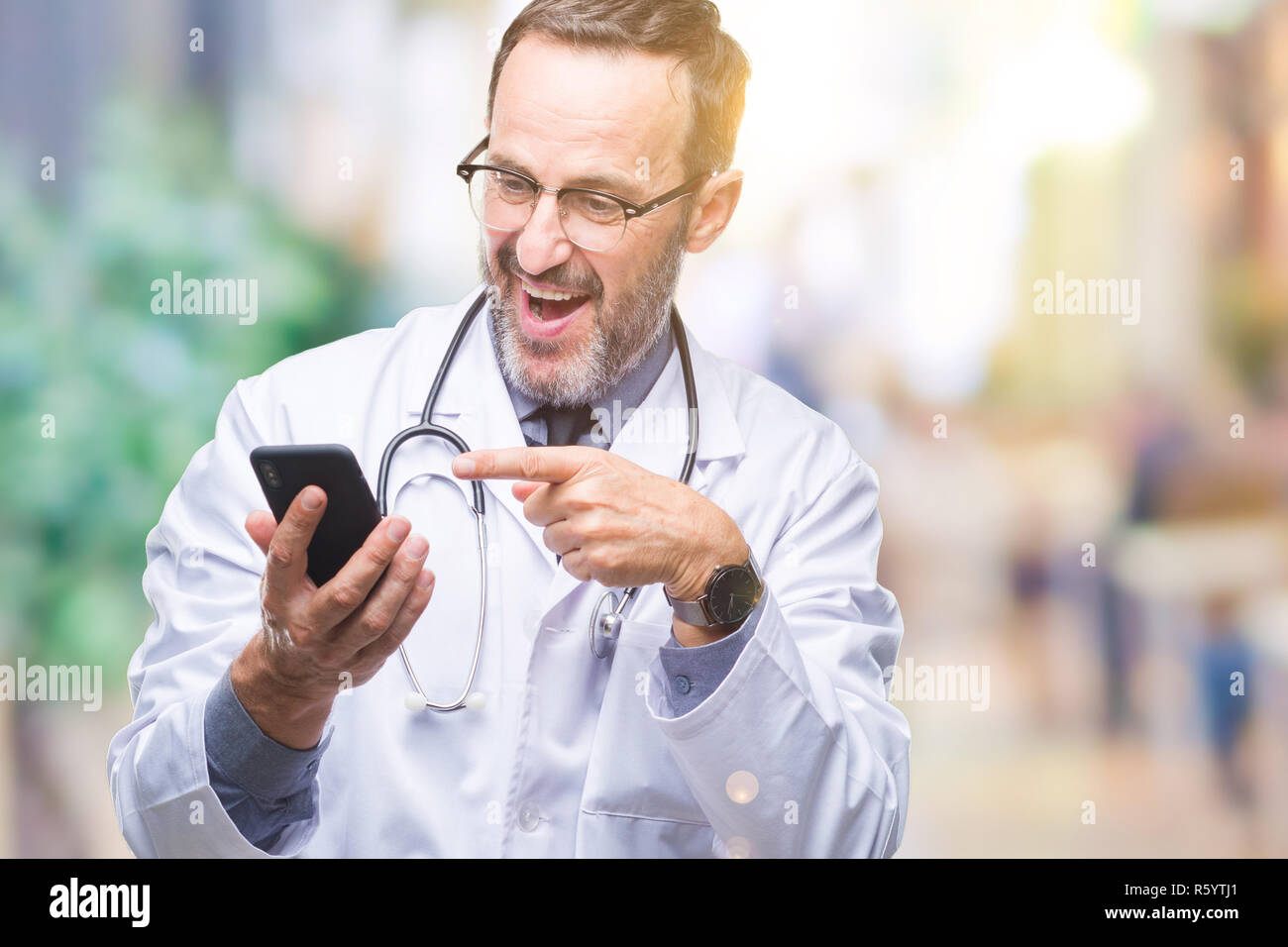 Middle age senior hoary doctor man texting using smartphone over ...