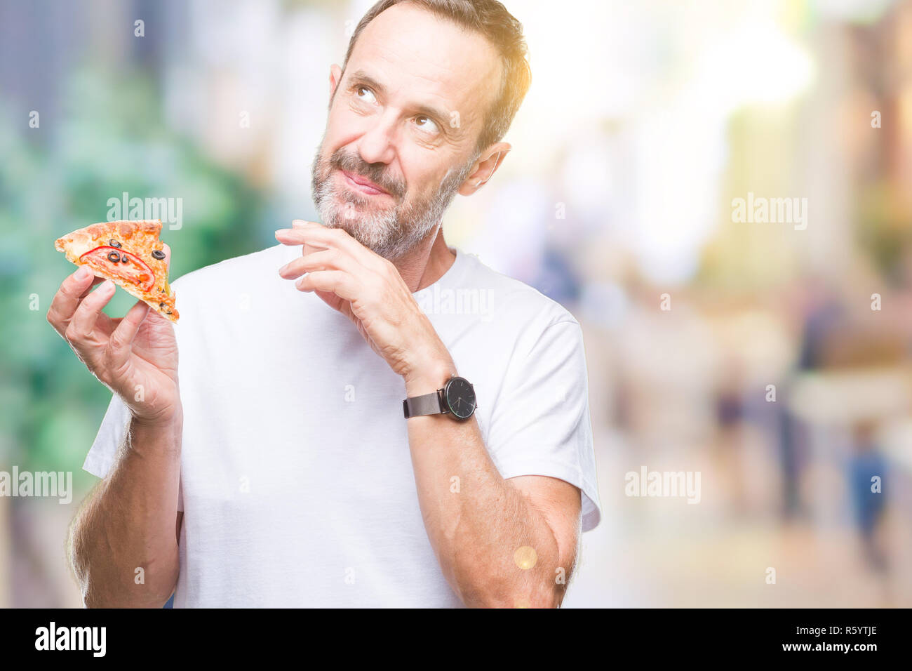 Middle age hoary senior man eating pizza slice over isolated background ...