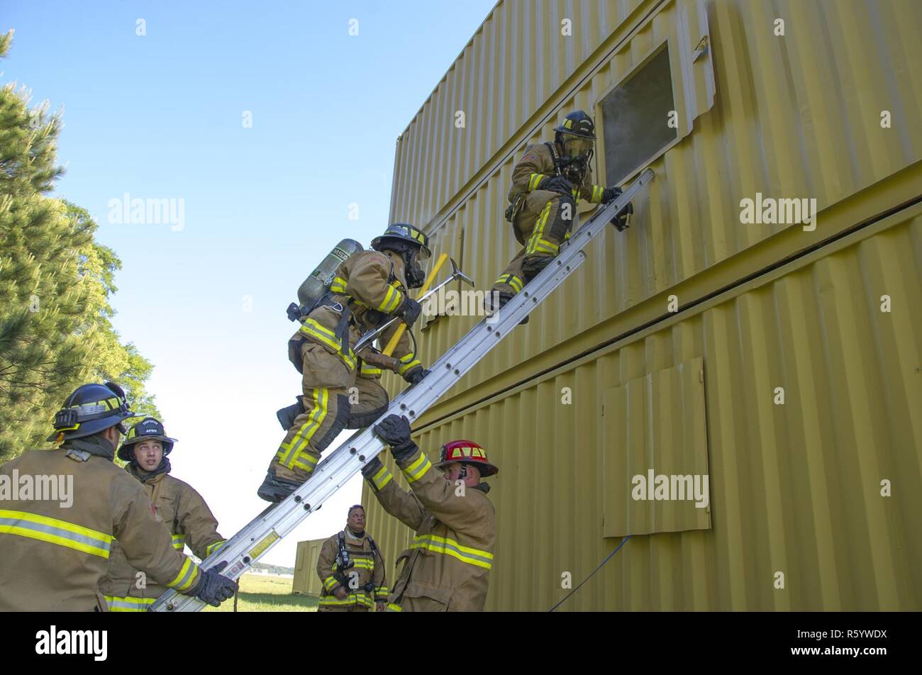 Air Force Reserve firefighters enter a building to rescue a downed ...