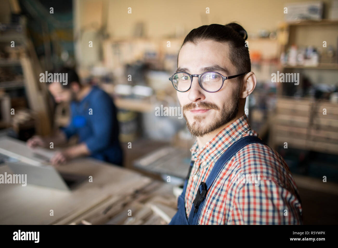 Head and shoulders portrait of trendy young man looking at camera while ...