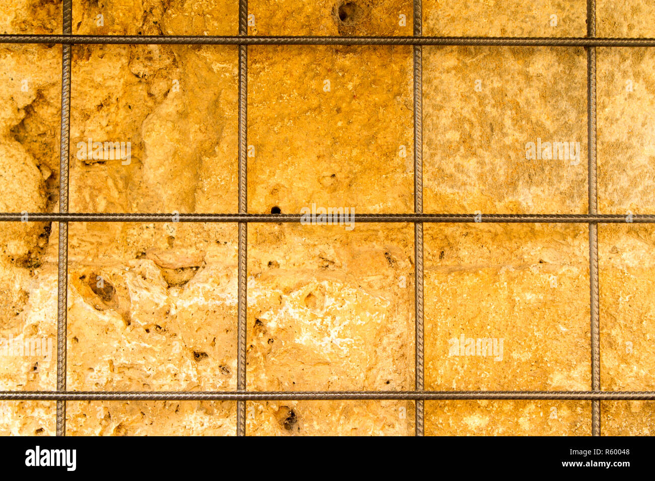square metal grid in front of a natural stone wall. backgrounds and ...
