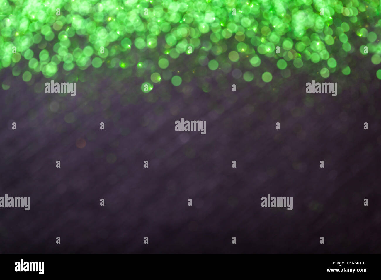 Black blurred background for Christmas greeting card with green lights ...