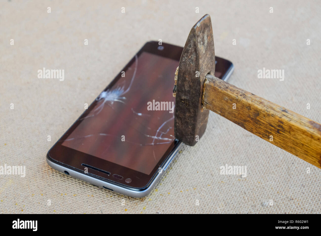 Hammer and smartphone. The screen of the smartphone, a broken ha Stock ...