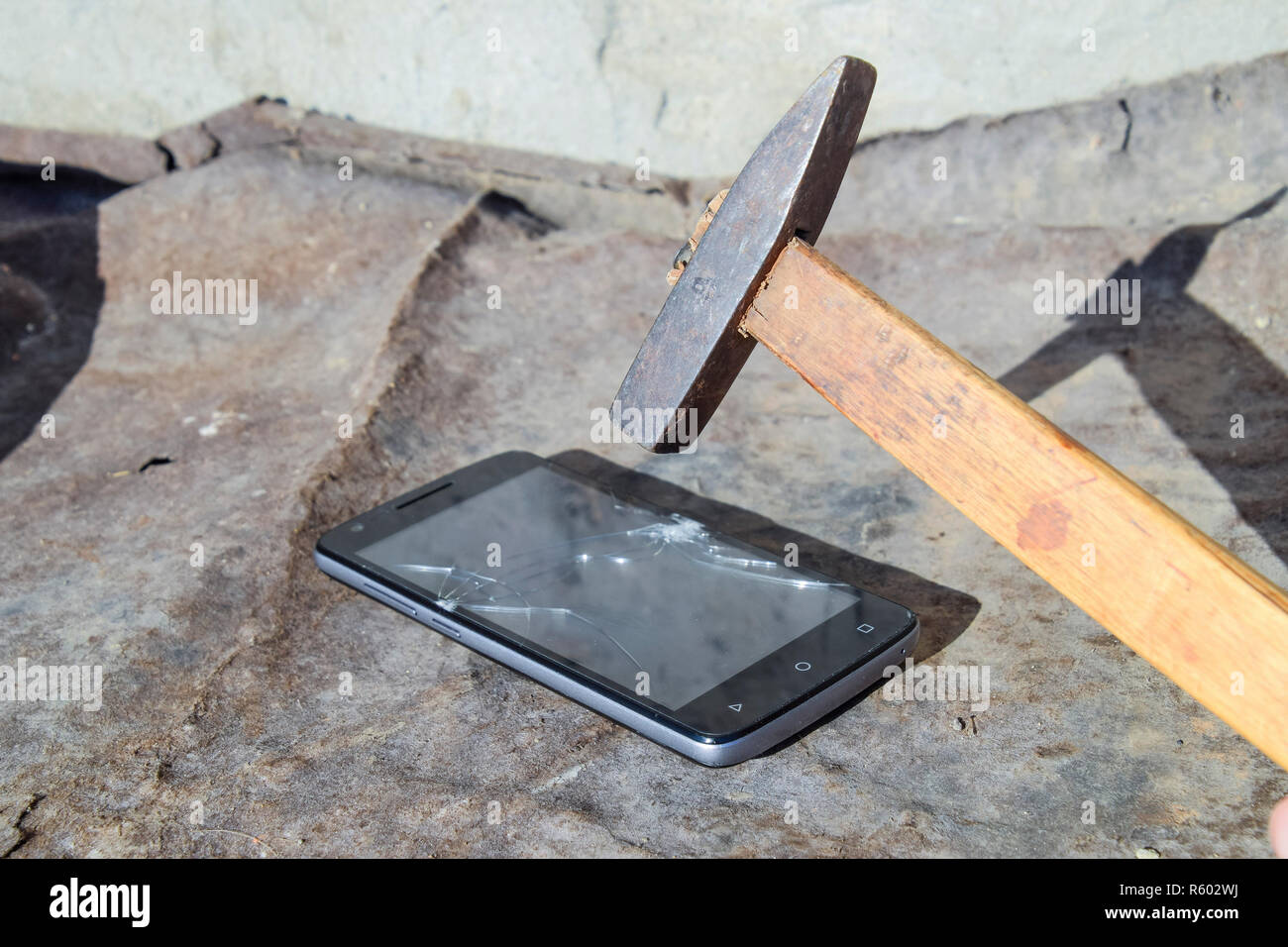 Hammer and smartphone. The screen of the smartphone, a broken ha Stock ...