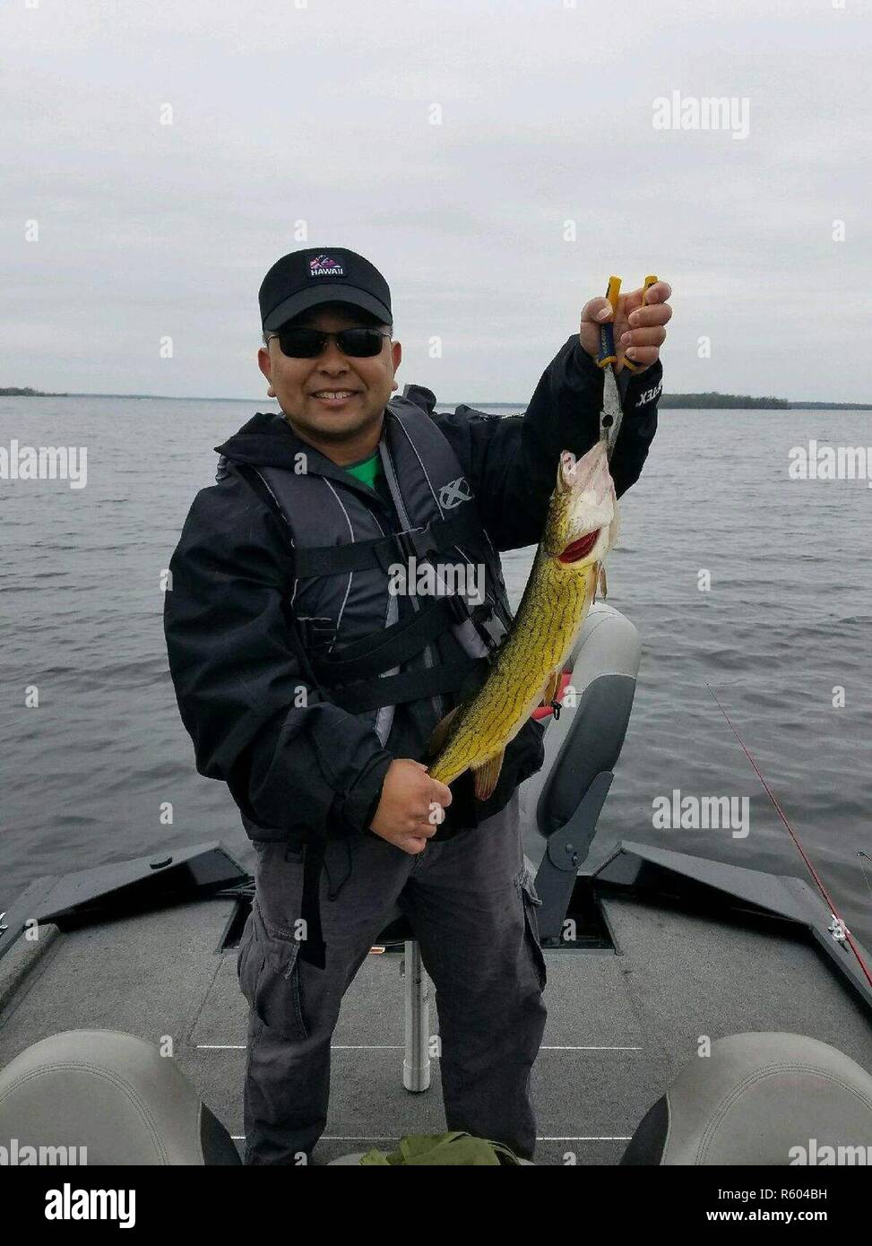 Sgt. 1st Class Sheldon Pajimola shows off a pickerel he caught during ...