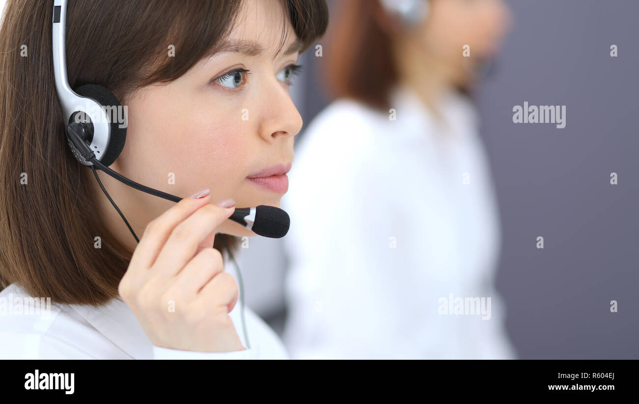 Call center. Group of operators at work. Focus on young brunette woman. Business concept Stock ...