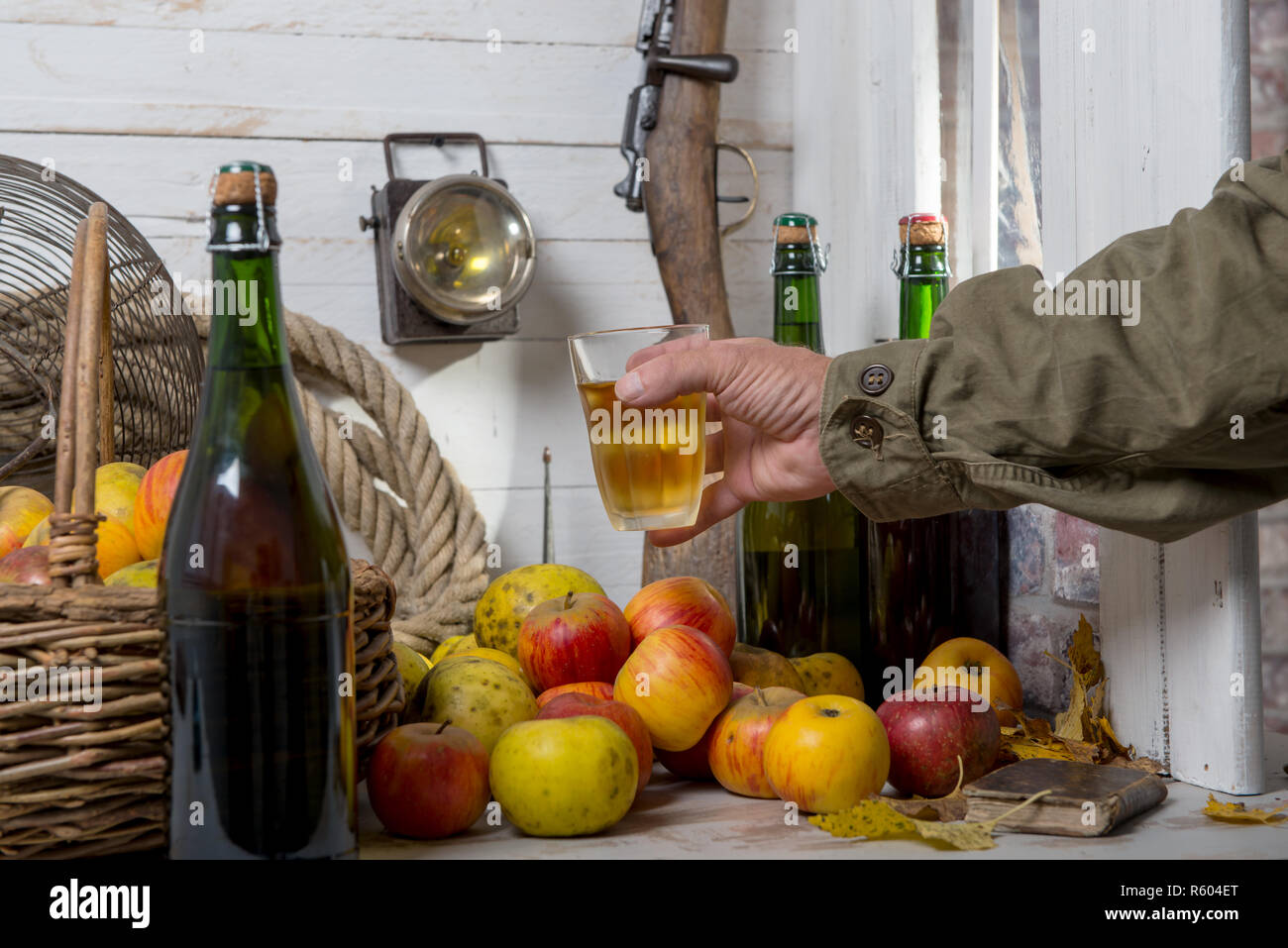 man with a bottle and glass of cider, apples at background Stock Photo ...