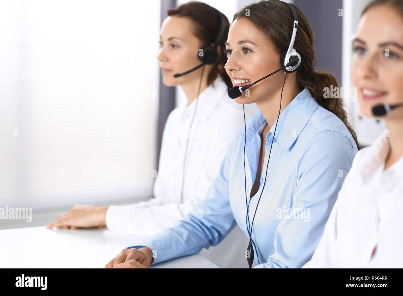Call center. Group of operators at work. Focus at beautiful business woman in headset Stock ...