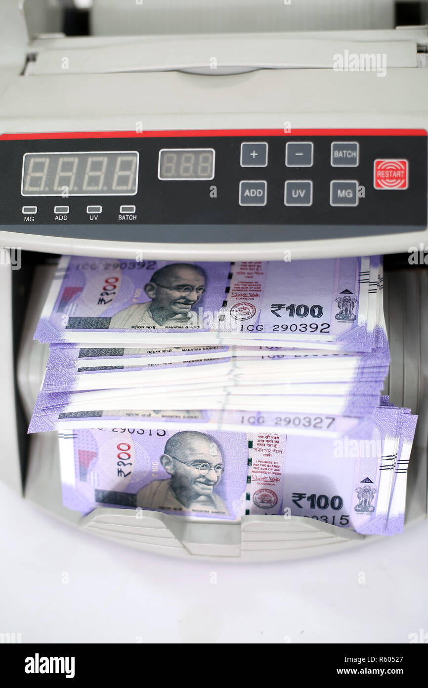 Electronic money counter with 100 rupees notes. Isolated on the white ...