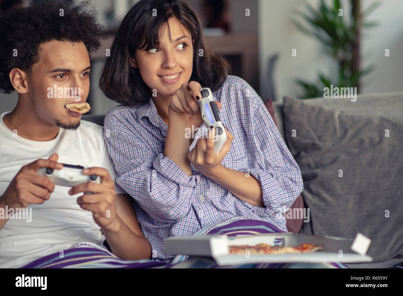 Image of young loving couple in kitchen at home indoors. Eating pizza ...