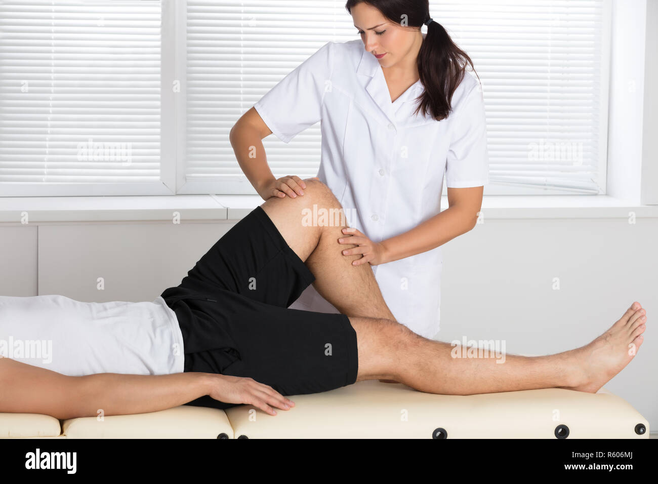 Physiotherapist Giving Leg Exercise In Clinic Stock Photo - Alamy