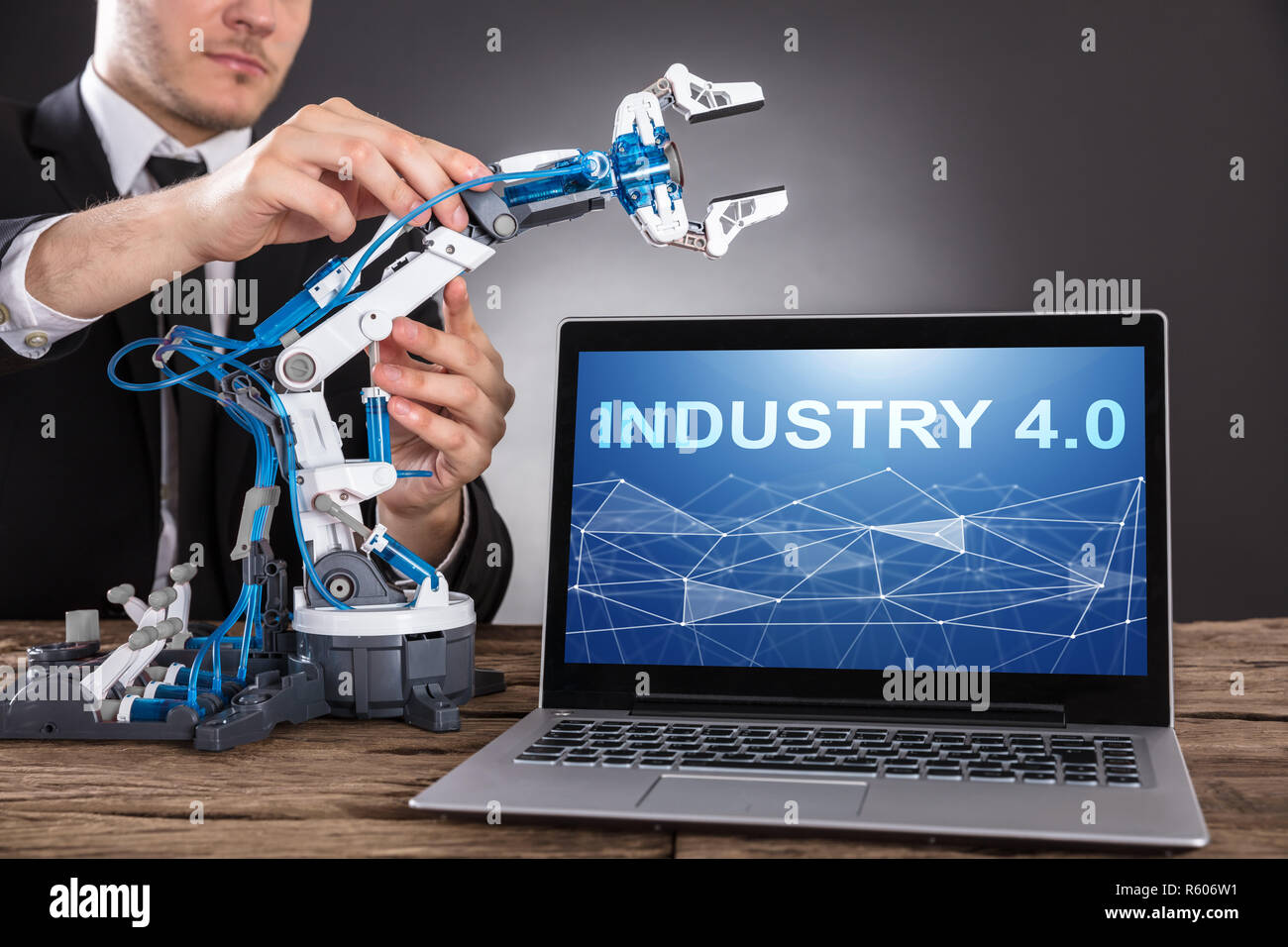 Businessman Building Robot With Laptop Showing Industry 4.0 Stock Photo ...