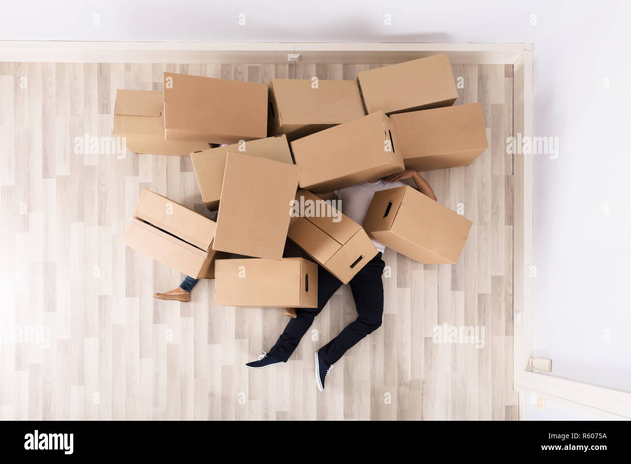 Couple Lying Under The Cardboard Boxes Stock Photo - Alamy