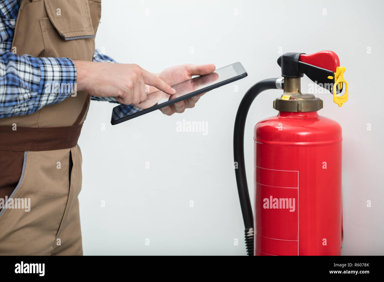 Technician Using Digital Tablet To Check Fire Extinguisher Stock Photo ...