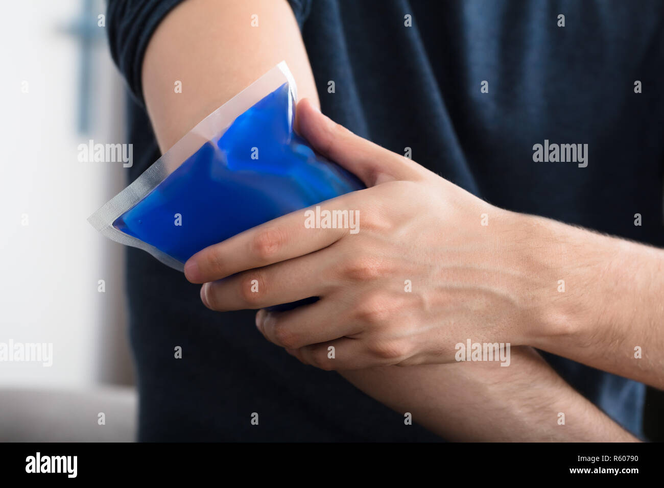 Person Applying Ice Gel Pack On An Injured Elbow Stock Photo - Alamy