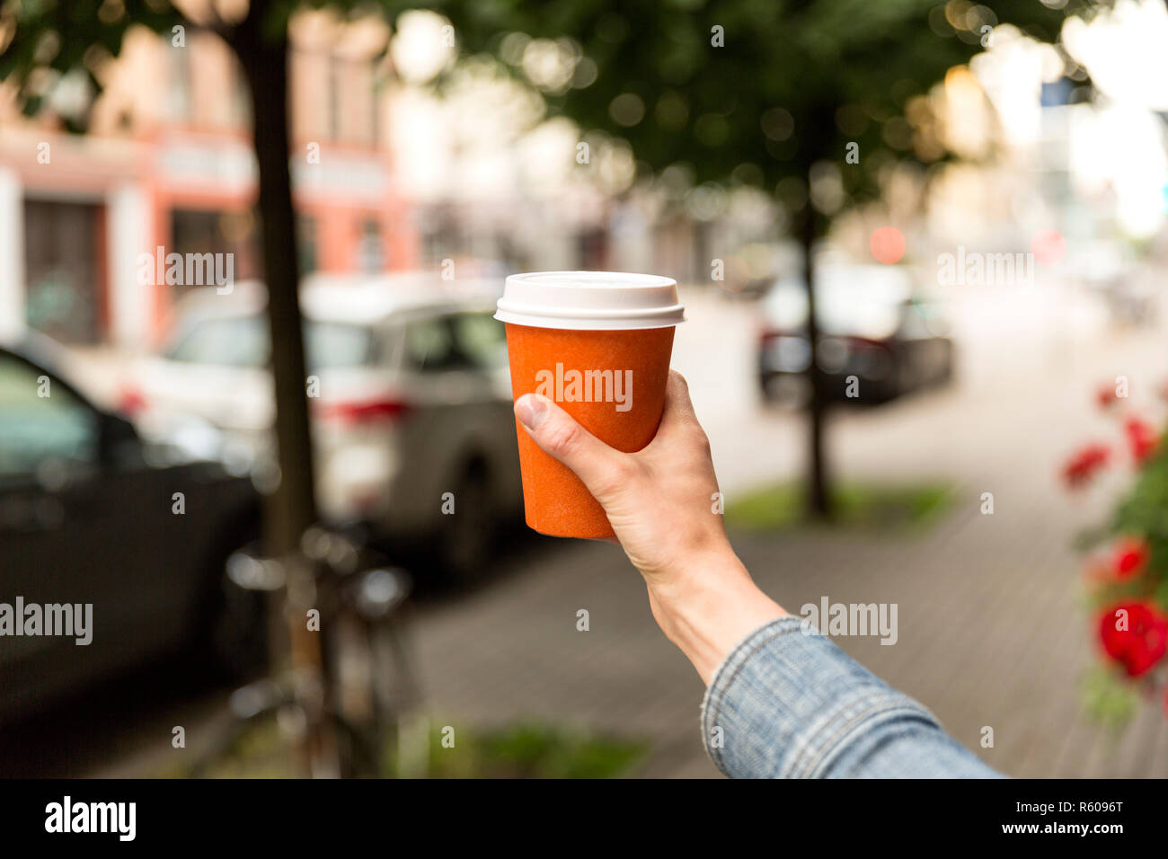 Woman's hand with coffee in paper cup, city view background Stock Photo ...