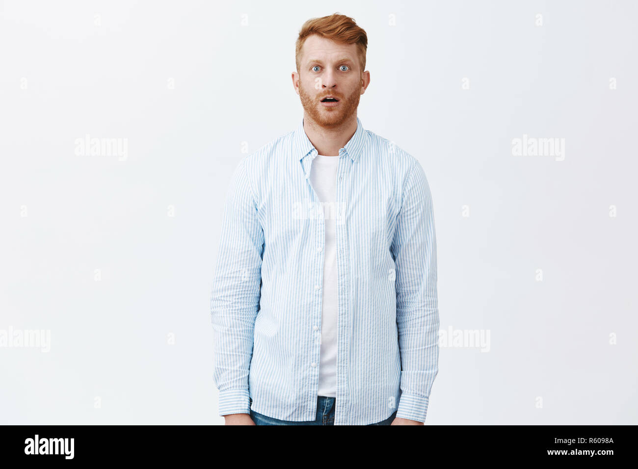 Redhead man standing like zombie in stunned, staring amazed at camera ...