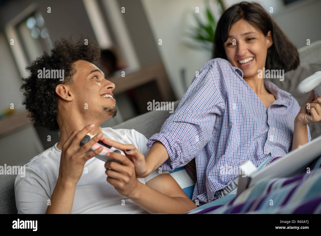 Young couple enjoying playing video games together Stock Photo - Alamy