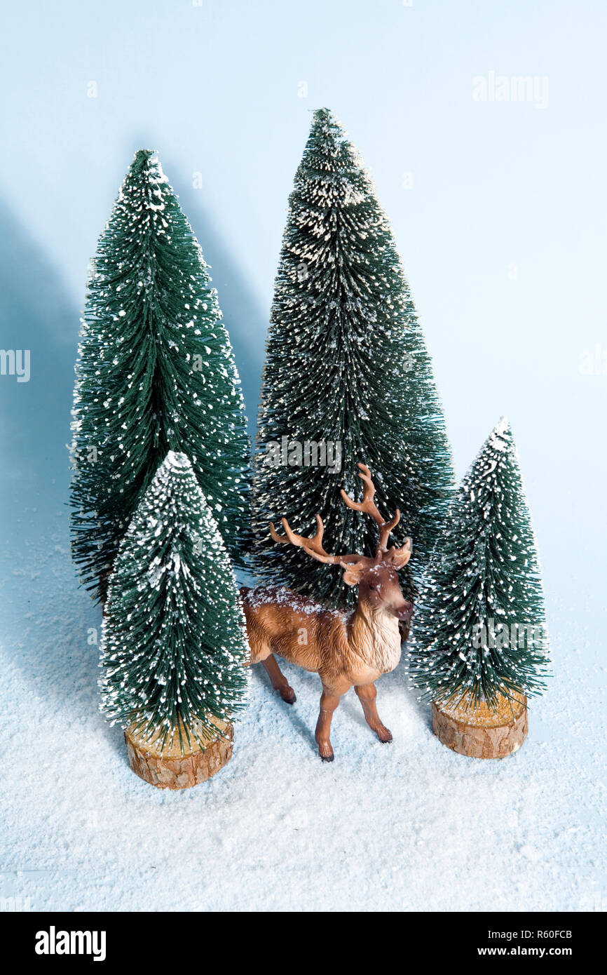 Snowy forest firs and reindeer blue Stock Photo - Alamy
