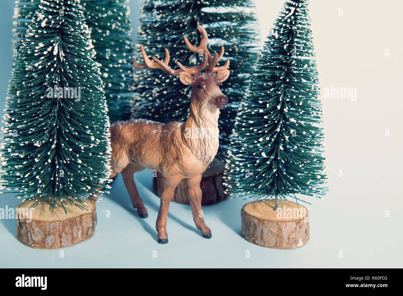 Snowy forest firs and reindeer blue Stock Photo - Alamy