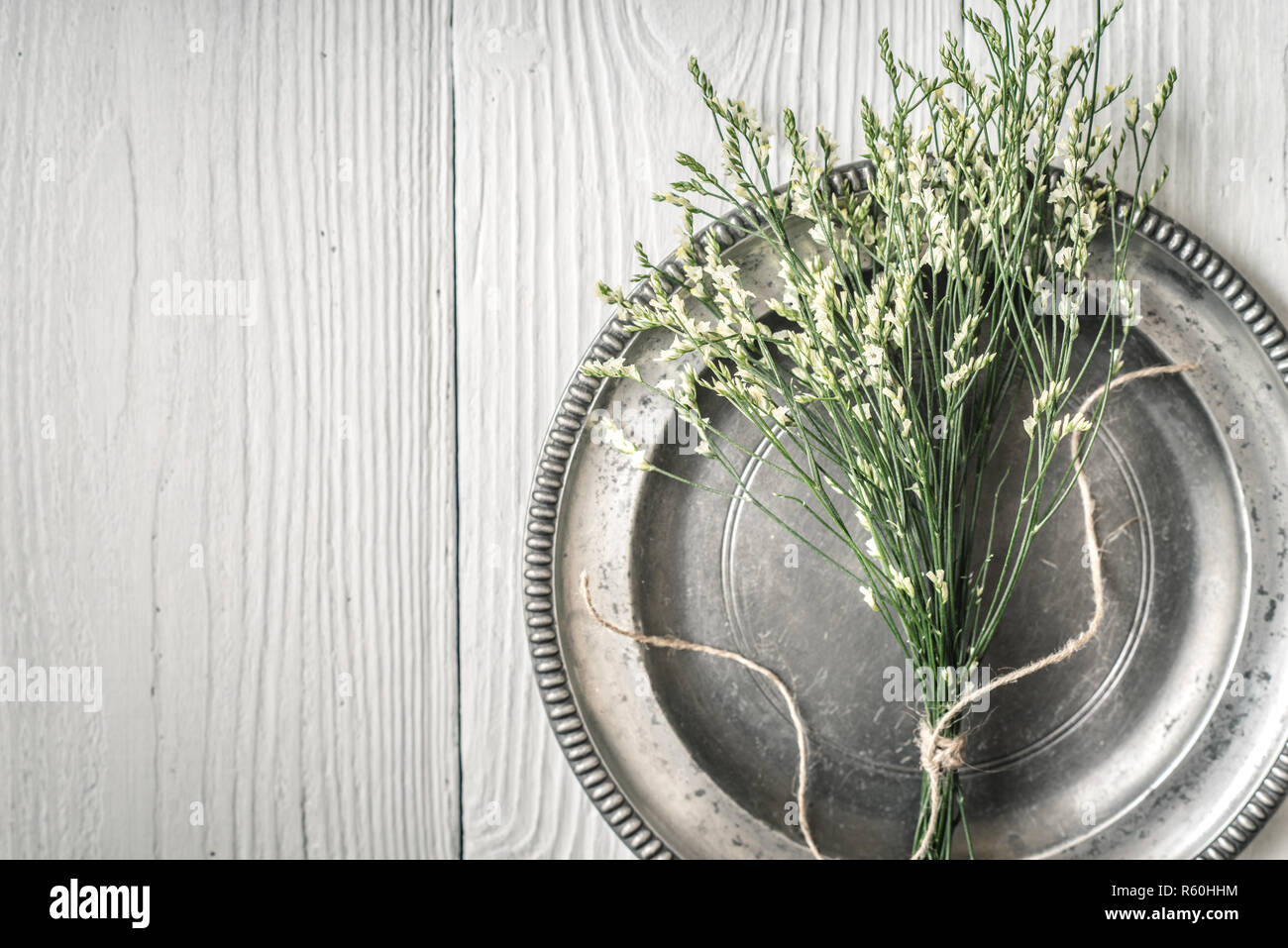 Flowers in the metal plate on the white wooden table top view Stock ...