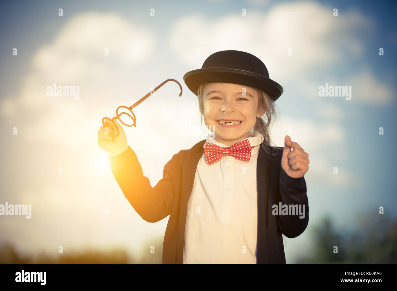Funny little girl in bow tie and bowler hat Stock Photo - Alamy