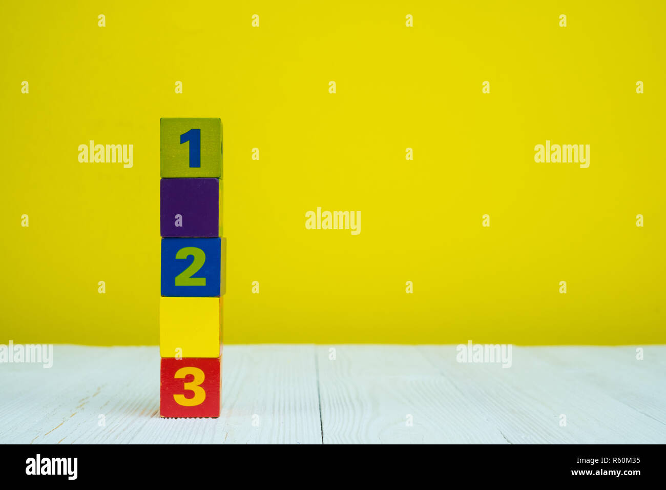 Square block puzzle number 1 2 and 3 on table with yellow wall ...