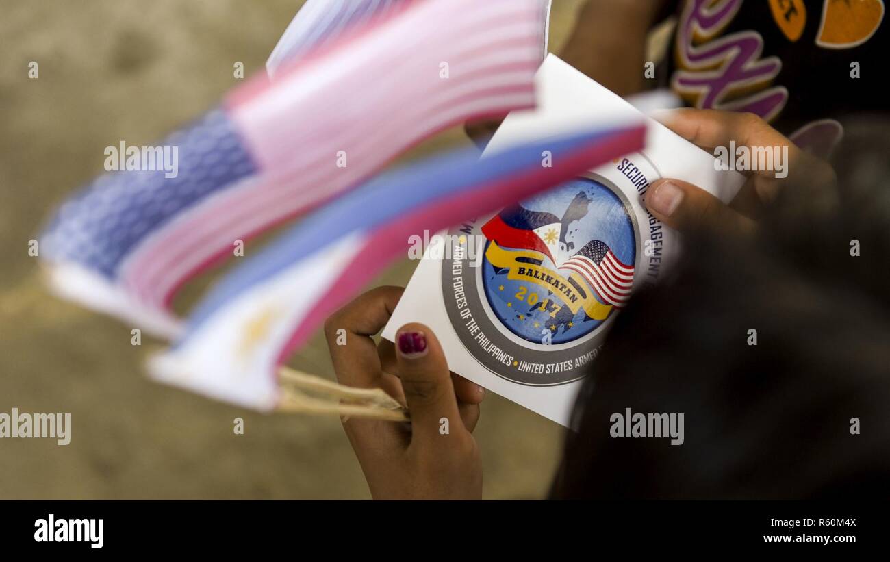 A Filipino girl reads a Balikatan 2017 sticker during a groundbreaking ...
