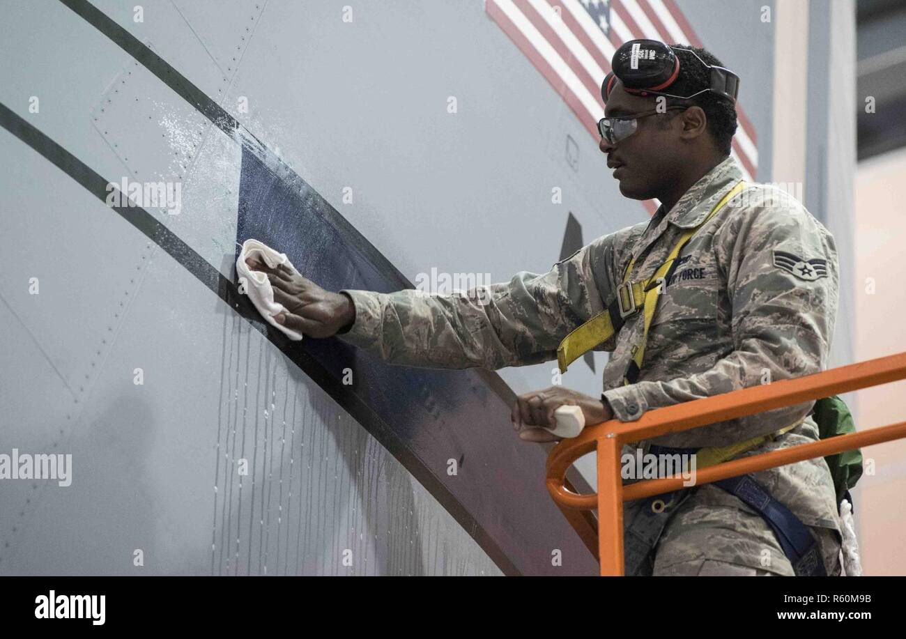 Senior Airman Eric Ervin smooths the background of a decal on the tail ...