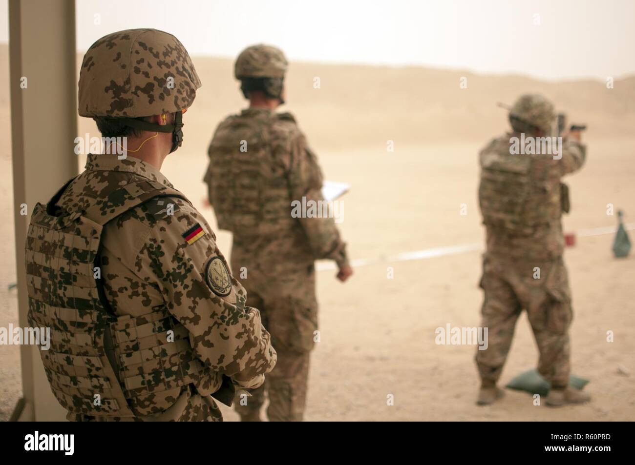 A German officer supervises as U.S. Army Central Command Soldiers fire ...