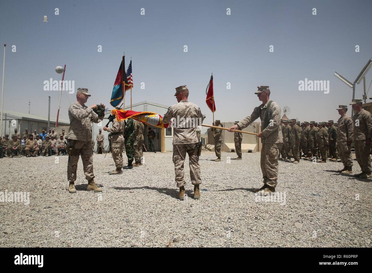 Col. Matthew Reid, left, and Sgt. Maj. Darrell Carver, center, unfurl ...
