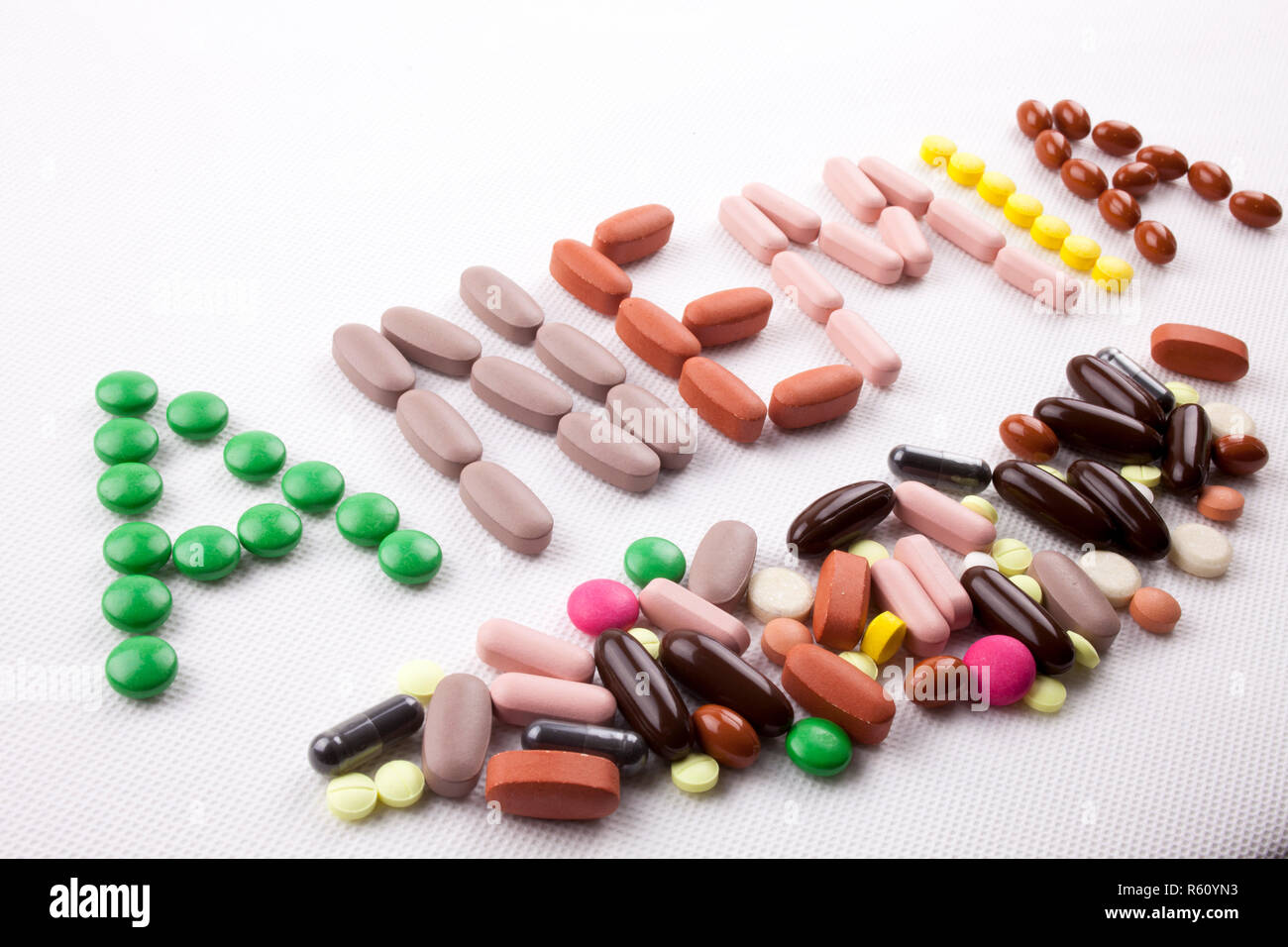 Hand writing Medical care concept written with pills drugs capsule word ...