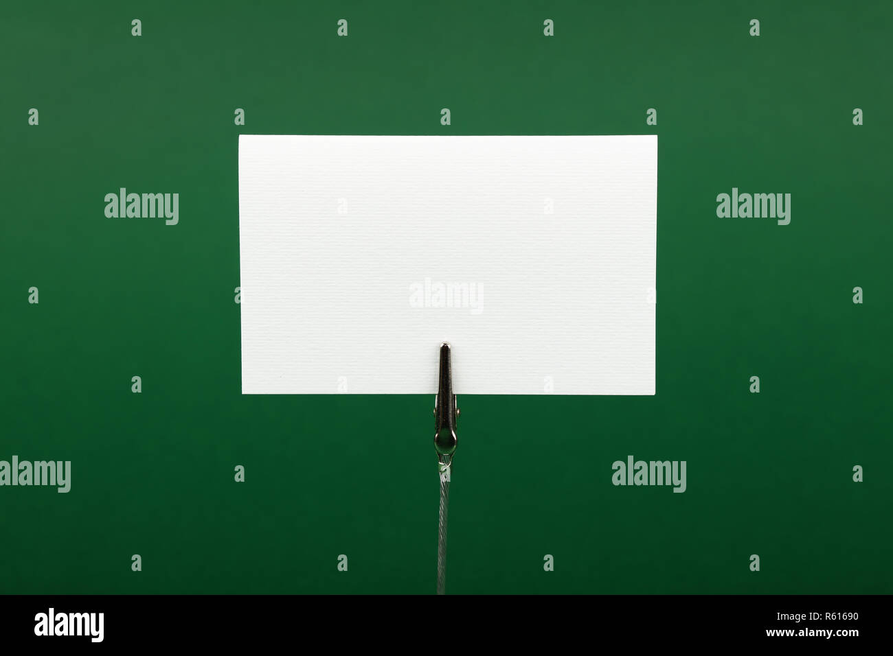 Blank white paper sign over green background Stock Photo - Alamy