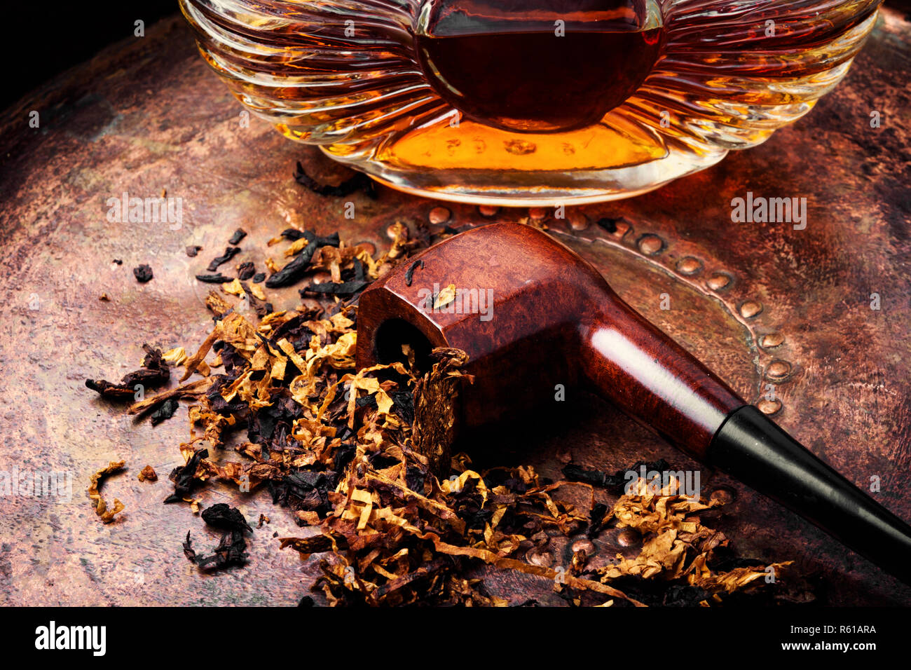 Glass of cognac and pipe with tobacco on retro table Stock Photo - Alamy