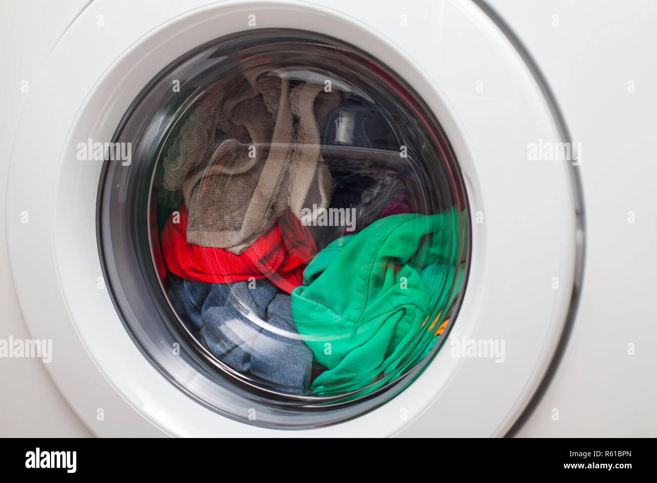 Modern automatic washing machine loaded with colorful clothes Stock ...
