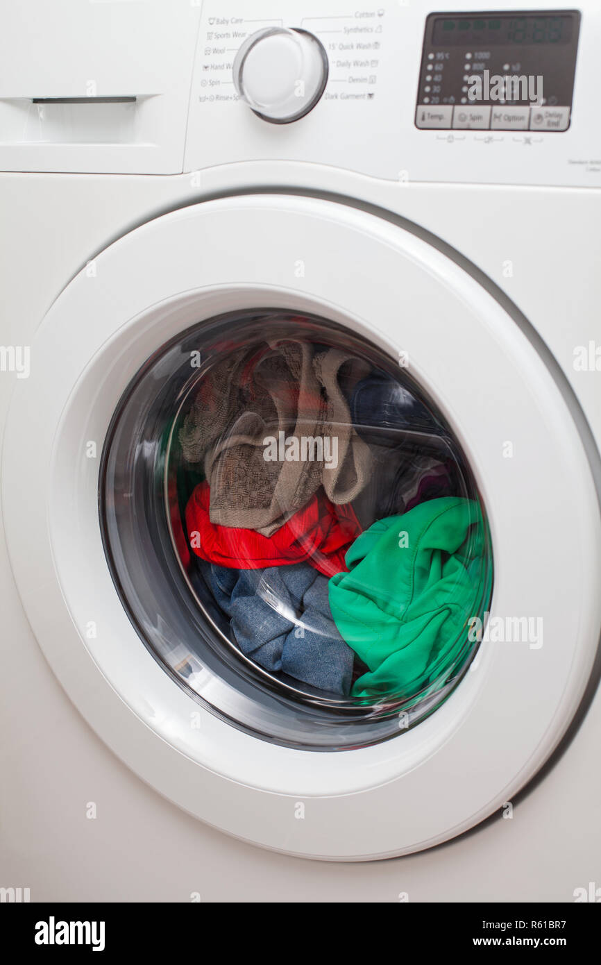 Modern automatic washing machine loaded with colorful clothes Stock ...
