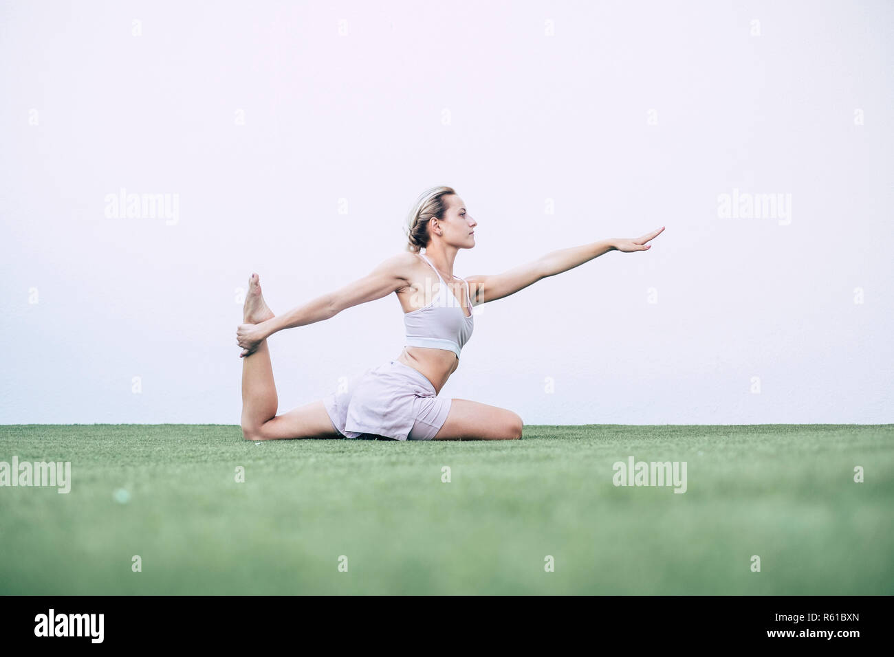 beautiful young blonde girl doing pilates yoga balanced position at ...