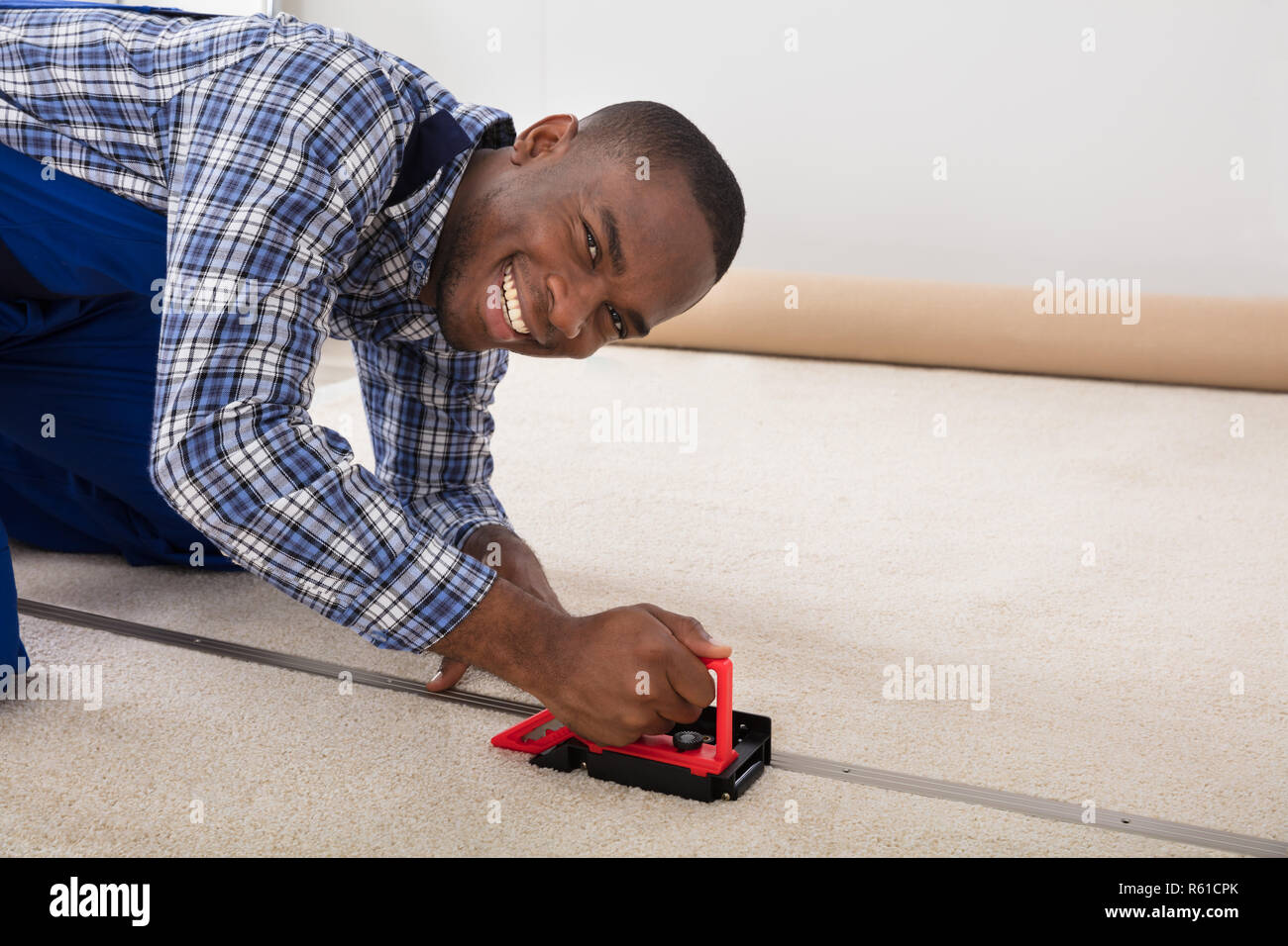 Young Craftsman Fitting Carpet Stock Photo - Alamy