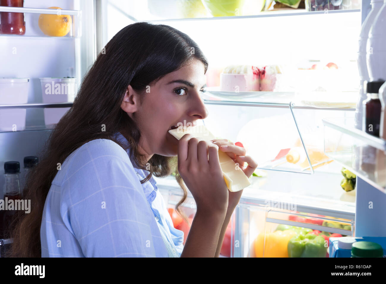 Woman Eating Slice Of Cheese Stock Photo - Alamy