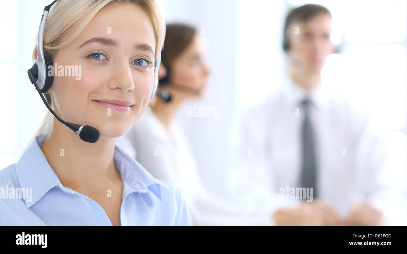 Call center. Group of operators at work. Focus at blonde business woman ...