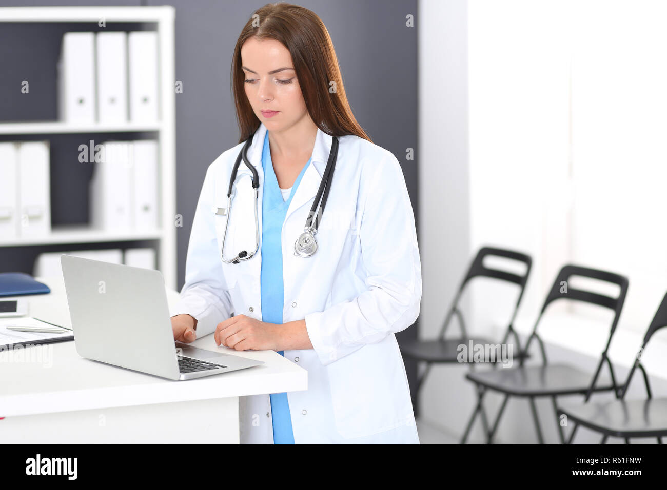 Doctor woman at work. Portrait of female physician using laptop ...