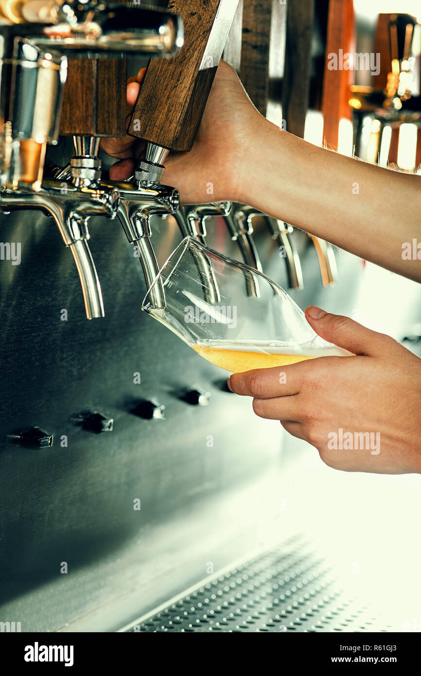 Hand of bartender pouring a large lager beer in tap Stock Photo - Alamy